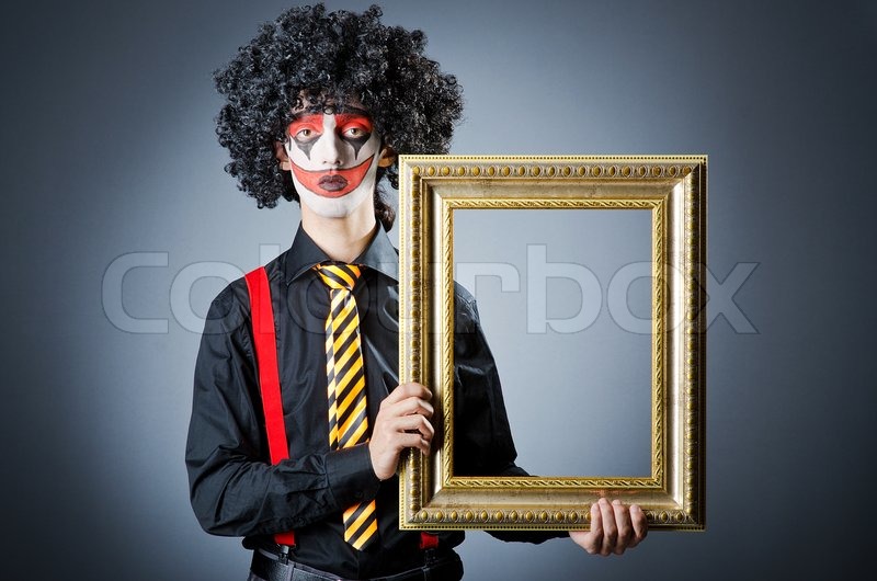 Clown with picture frames in studio | Stock image | Colourbox