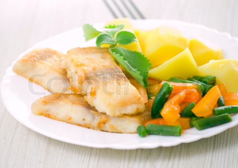Fried fish with vegetables and potato for dinner | Stock Photo | Colourbox