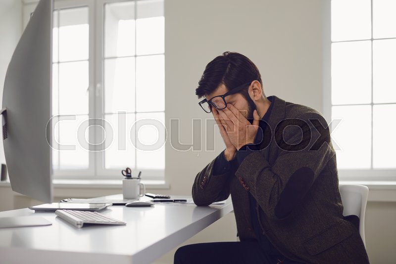 Exhausted tired worker at the workplace ... | Stock image | Colourbox
