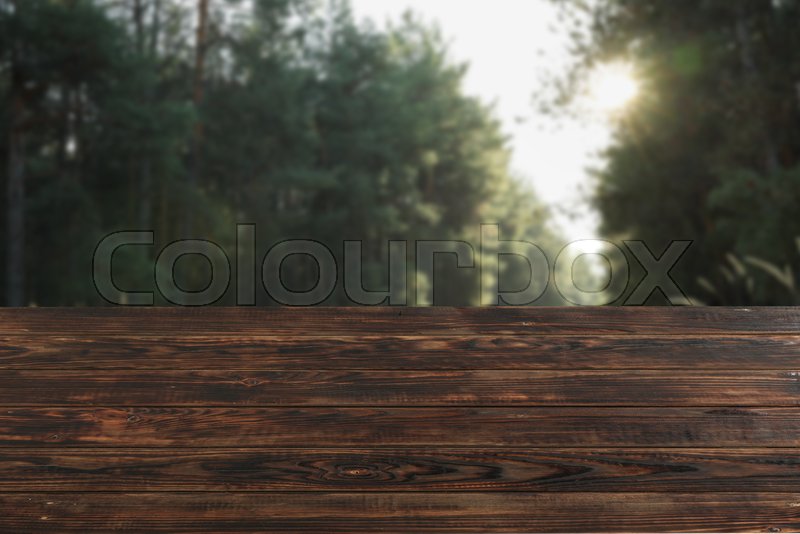 Wooden table against beautiful forest. ... | Stock image | Colourbox