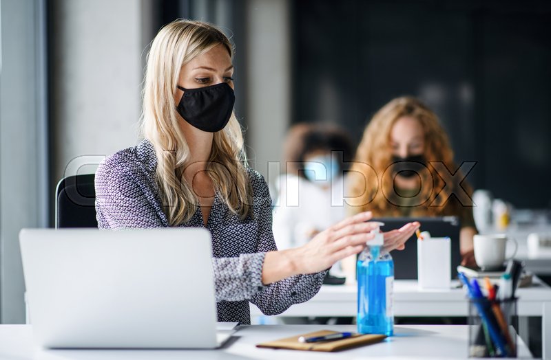 Young woman with face mask at desks ... | Stock image | Colourbox
