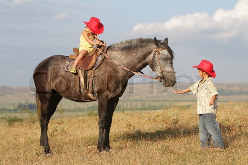 Two happy children riding horse on ... | Stock image | Colourbox