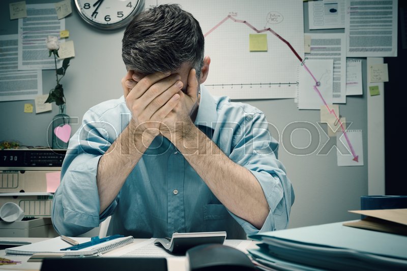 Desperate office worker with head in ... | Stock image | Colourbox