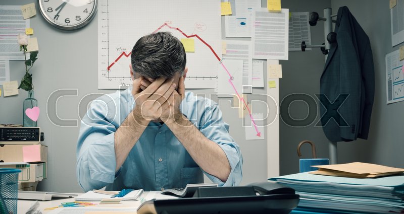 Desperate office worker with head in ... | Stock image | Colourbox