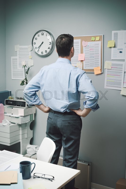 Office worker standing at workplace ... | Stock image | Colourbox