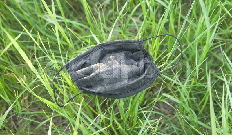 Face mask on green grass background. | Stock image | Colourbox