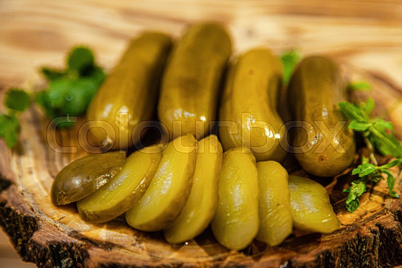Whole and sliced marinated pickles on a ... | Stock image | Colourbox