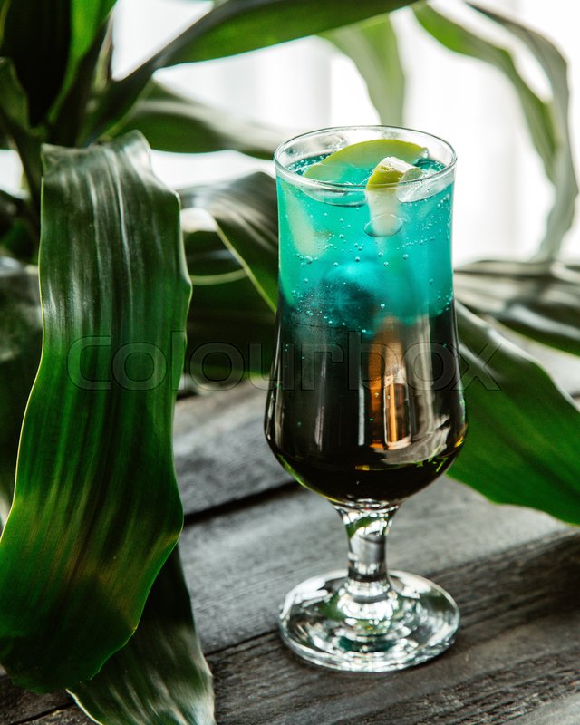 A glass of green cocktail garnished ... | Stock image | Colourbox
