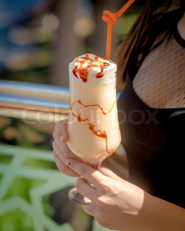 Woman holding Milkshake glass with ... | Stock image | Colourbox