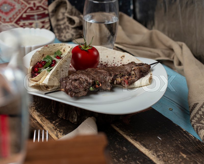 Meat barbecue served with tomato served ... | Stock image | Colourbox