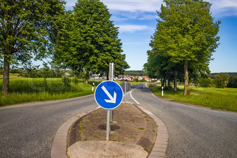 Country road with blue traffic sign and ... | Stock image | Colourbox