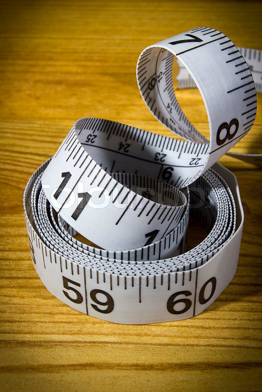 White tailor meter on a wooden table | Stock image | Colourbox