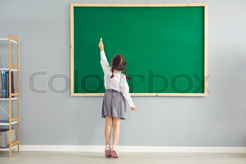 Back view of little girl writing on ... | Stock image | Colourbox