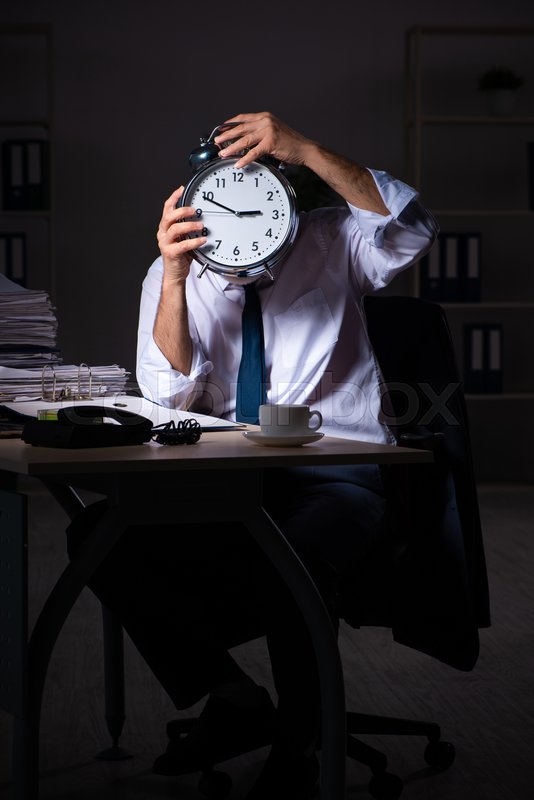 Old male employee working late at the ... | Stock image | Colourbox