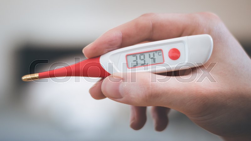 Man holds a red fever thermometer with ... | Stock image | Colourbox