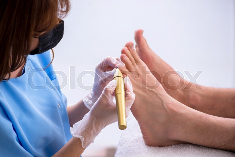 Podiatrist treating feet during the ... | Stock image | Colourbox