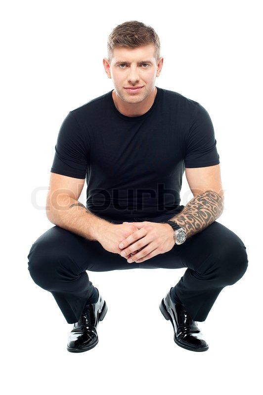 Handsome male bouncer squatting ... | Stock image | Colourbox