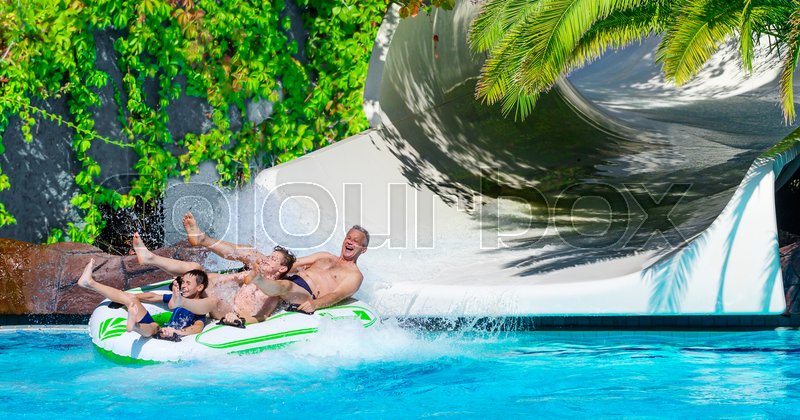 Family having fun on water slide at ... | Stock image | Colourbox
