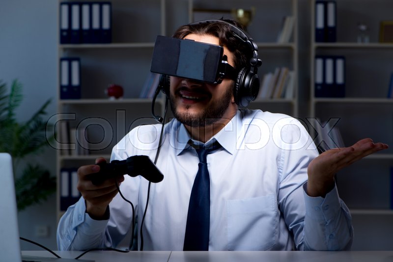 Businessman gamer staying late to play ... | Stock image | Colourbox