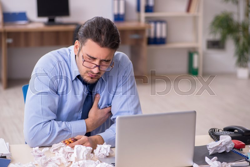 Sick male employee suffering at the ... | Stock image | Colourbox