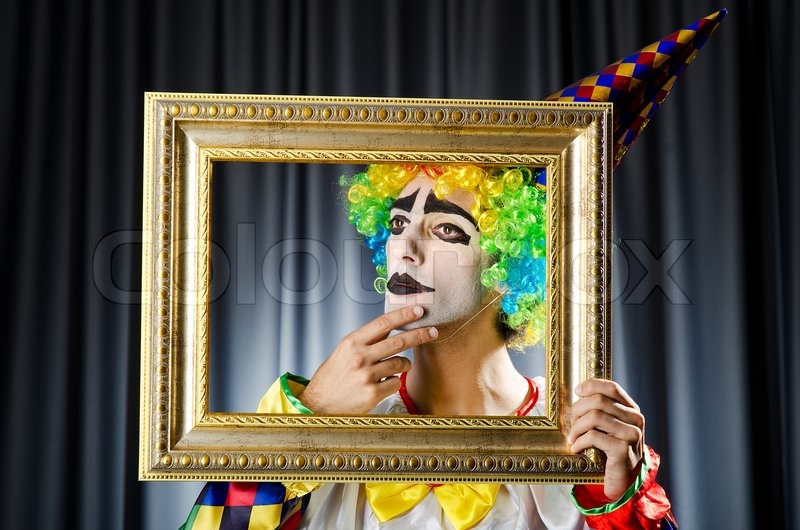 Clown with picture frames in studio | Stock Photo | Colourbox