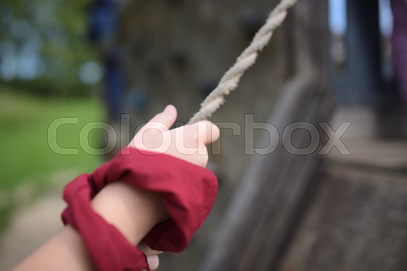 A kid holding on to a rope on a ... | Stock image | Colourbox
