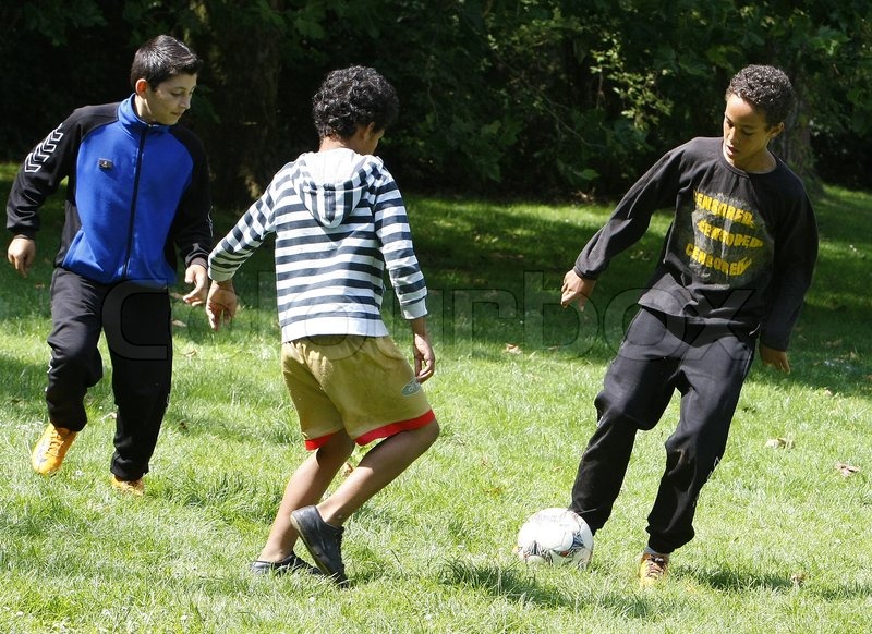 3 boys playing soccer on a lawn | Stock Photo | Colourbox
