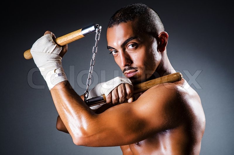 Strong man with nunchaku | Stock image | Colourbox