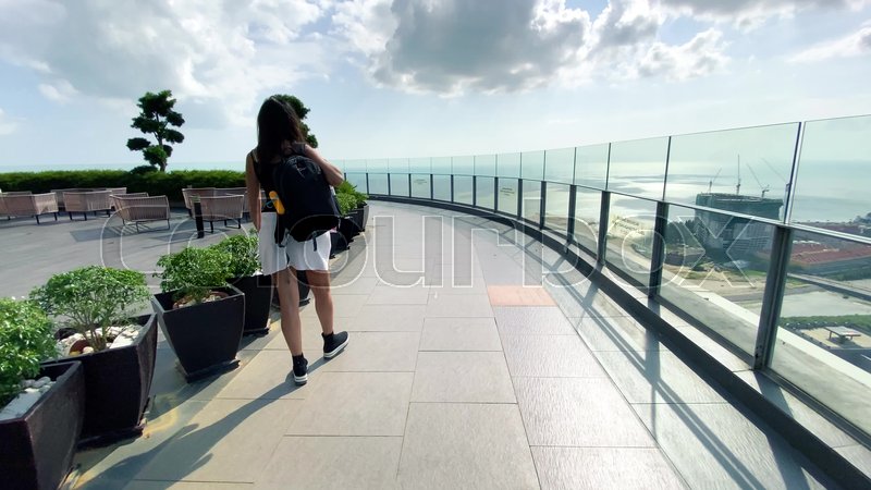 Woman walking along a city terrace with ... | Stock video | Colourbox
