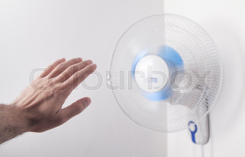 Male hand with electric fan in home. | Stock image | Colourbox