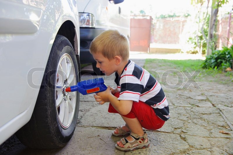 Lillte child playing in auto mechanic | Stock image | Colourbox