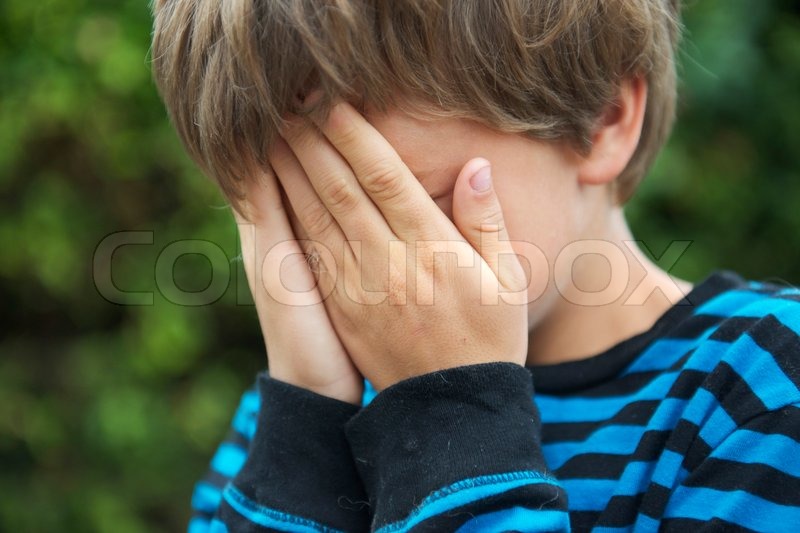 Scared or shy boy with hands covering ... | Stock image | Colourbox
