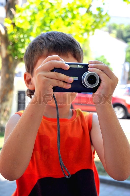 Little boy holding digital camera, he ... | Stock image | Colourbox