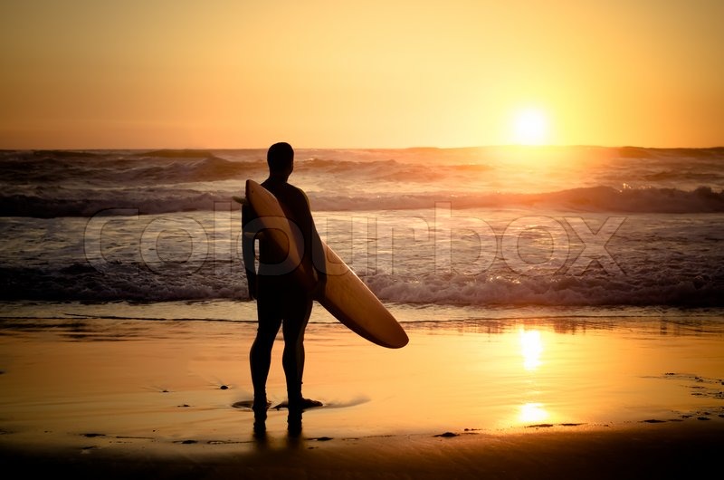 Surfer watching the waves at sunset in ... | Stock image | Colourbox