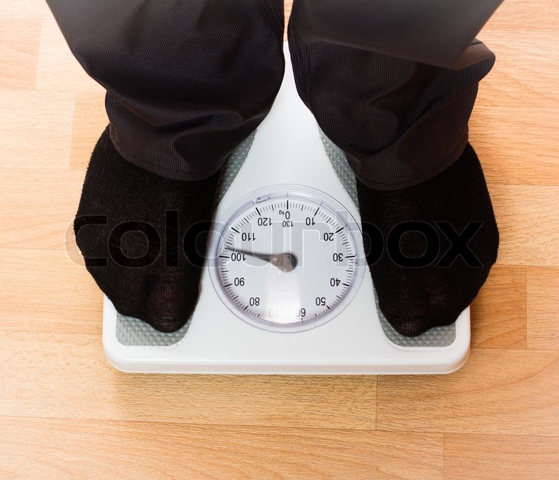 Overweight man on scales | Stock image | Colourbox