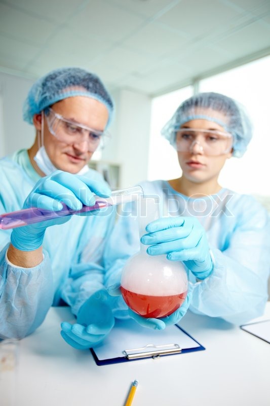 Laboratory workers mixing two chemical ... | Stock image | Colourbox