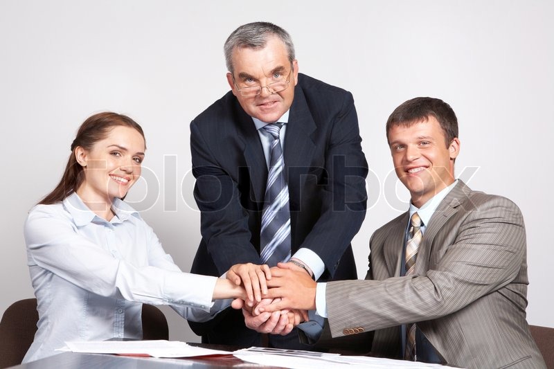 Photo of three partners putting their ... | Stock image | Colourbox