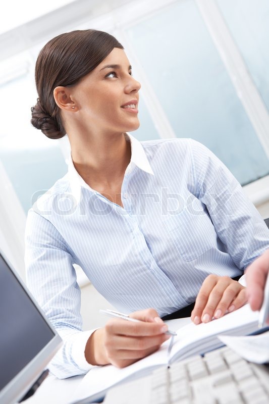 Portrait of young secretary sitting at ... | Stock image | Colourbox