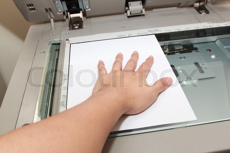 Hand pressing paper on a copy machine | Stock image | Colourbox