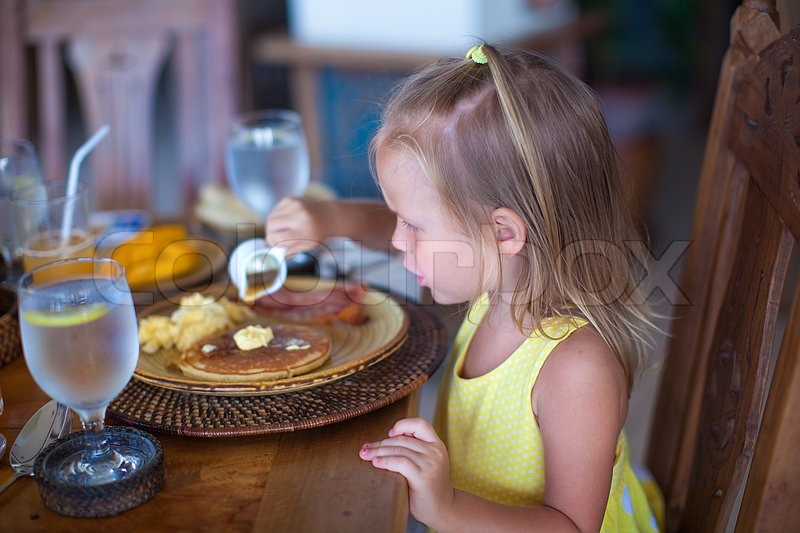 Adorable little girl having breakfast ... | Stock image | Colourbox