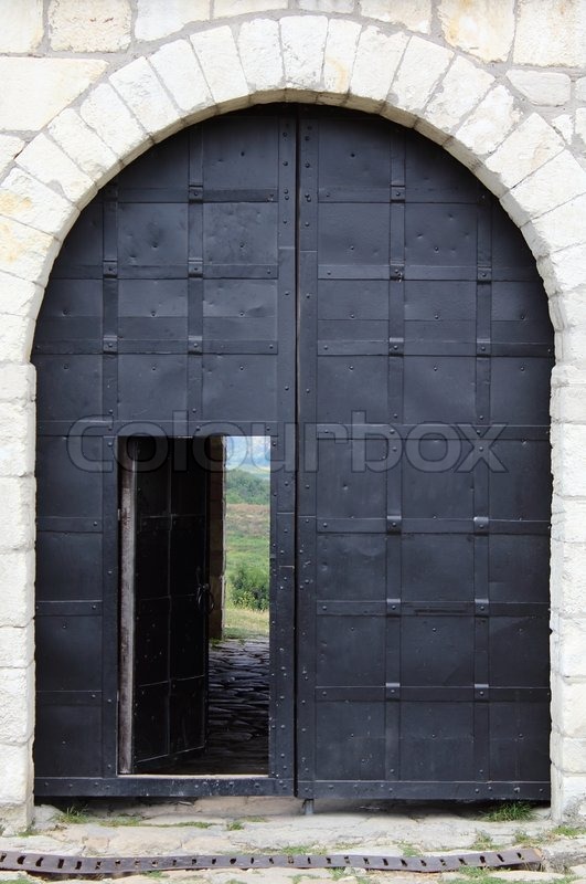 Big iron gates with opened door in the ... | Stock image | Colourbox