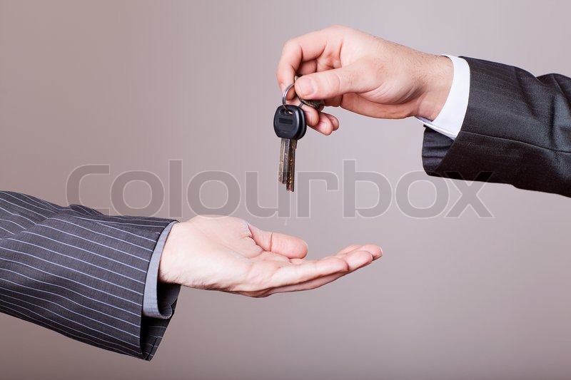 Man's hand giving keys to another man | Stock image | Colourbox