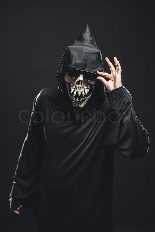 Terrible skeleton in a black robe holds ... | Stock image | Colourbox