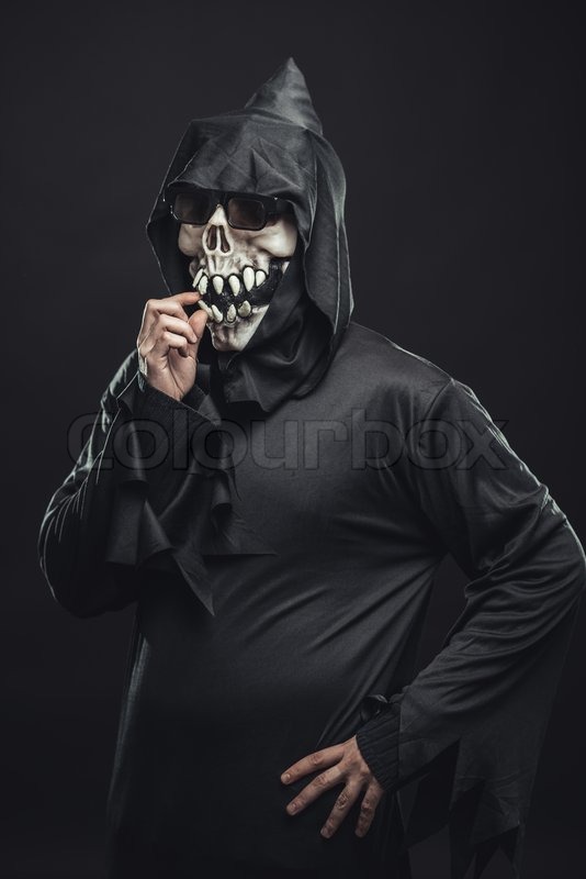 Scary skeleton in a robe picks his ... | Stock image | Colourbox