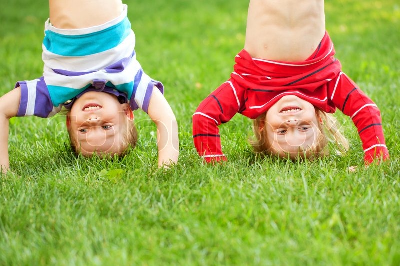 Happy children standing upside down on ... | Stock image | Colourbox
