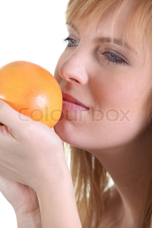 Woman smelling orange | Stock image | Colourbox