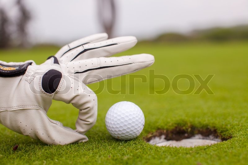 Golf player man pushing golf ball into ... | Stock image | Colourbox