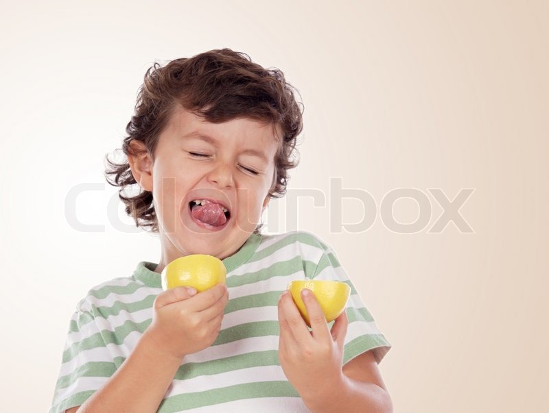 Cute boy eating lemon isolated on a ... | Stock image | Colourbox