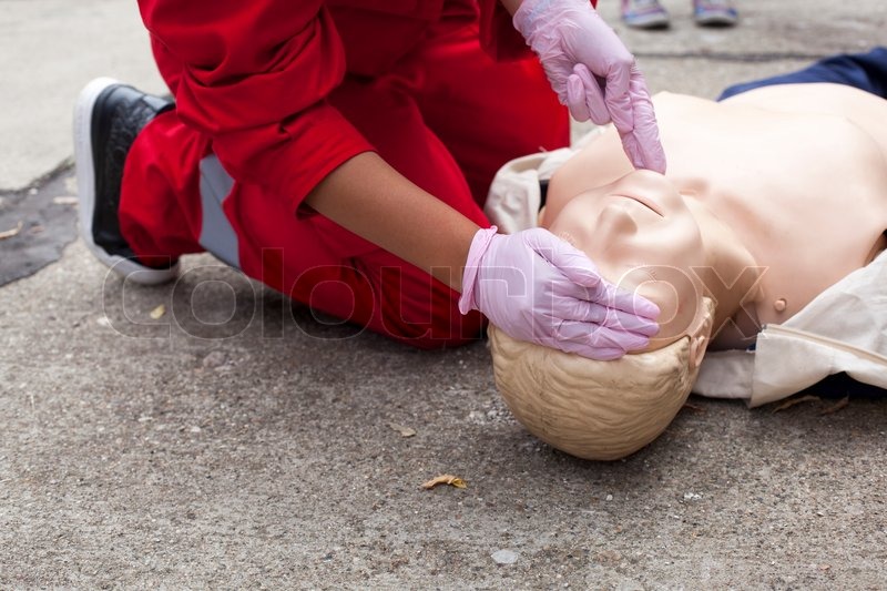 Paramedic demonstrates CPR on dummy | Stock image | Colourbox