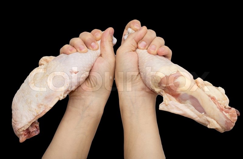 Chicken leg in hand on a black ... | Stock image | Colourbox